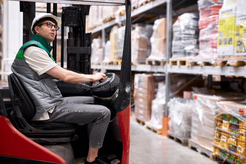 Professional Warehouse Worker Sit Inside of Machine, Doing Logistics ...