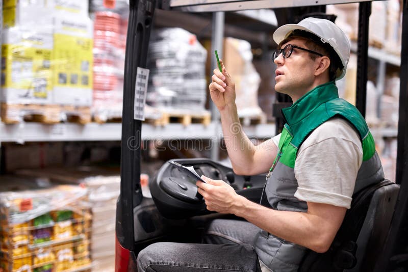 Professional Warehouse Worker Sit Inside of Machine, Doing Logistics ...