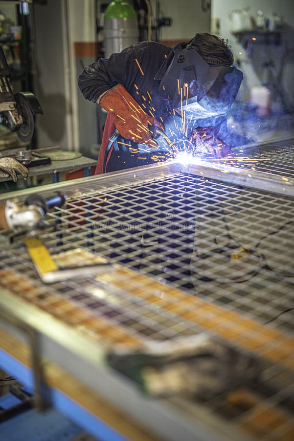 Professional Welder with Face Protection Mask Welding a Door in the ...