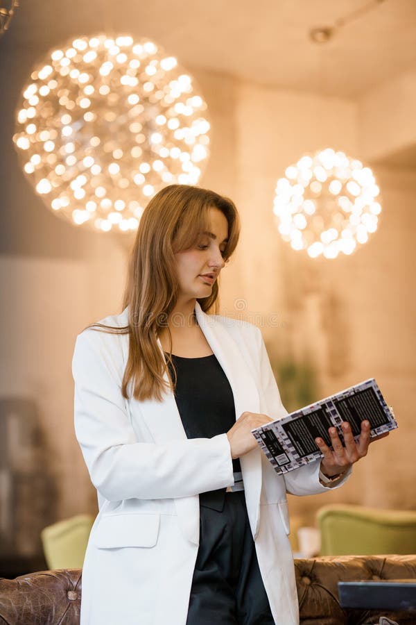 Professional Woman Browsing a Menu in a Modern Cafe with Elegant ...