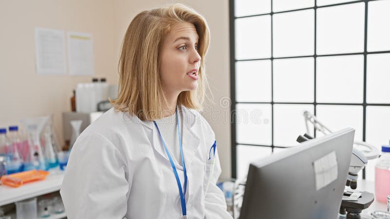 A Professional Woman in a Lab Coat Researches in a Clinical Laboratory ...