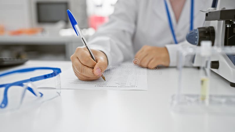 Professional Woman in Lab Coat Writing on a Form, with Microscope and ...