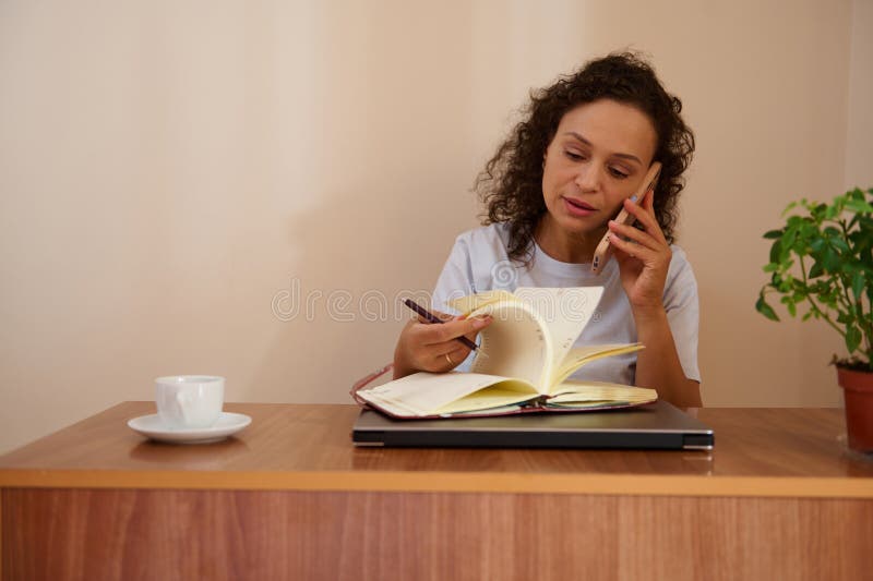 Professional Woman Multitasking with a Phone and Calendar at Home Stock ...