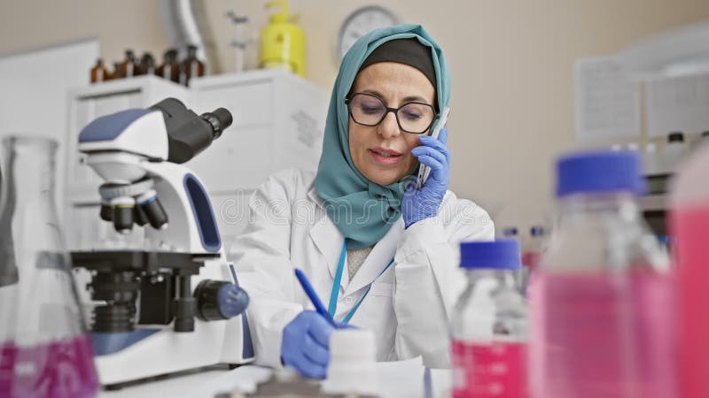 A Professional Woman Scientist in a Hijab Engaged in a Phone ...