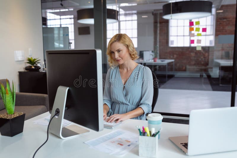 Professional Woman Typing on Computer at Office Desk, Focused and ...
