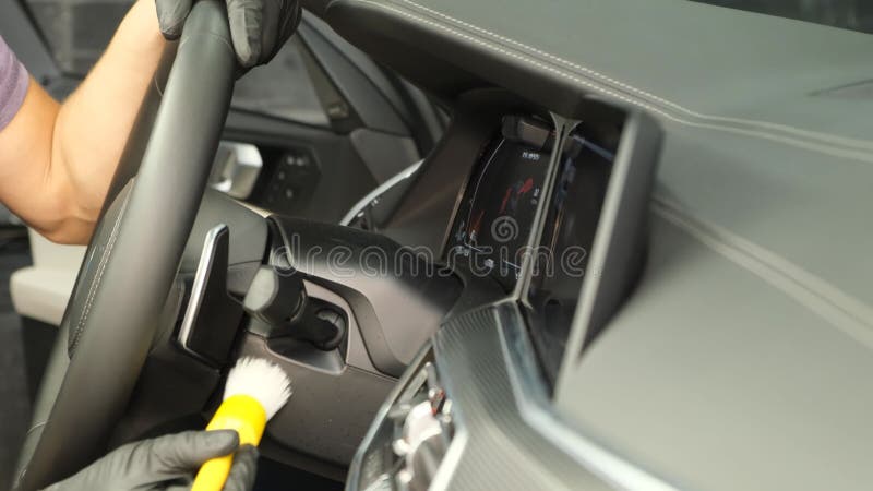 A Professional Worker Cleaning a Modern Car, Wiping the Dashboard ...