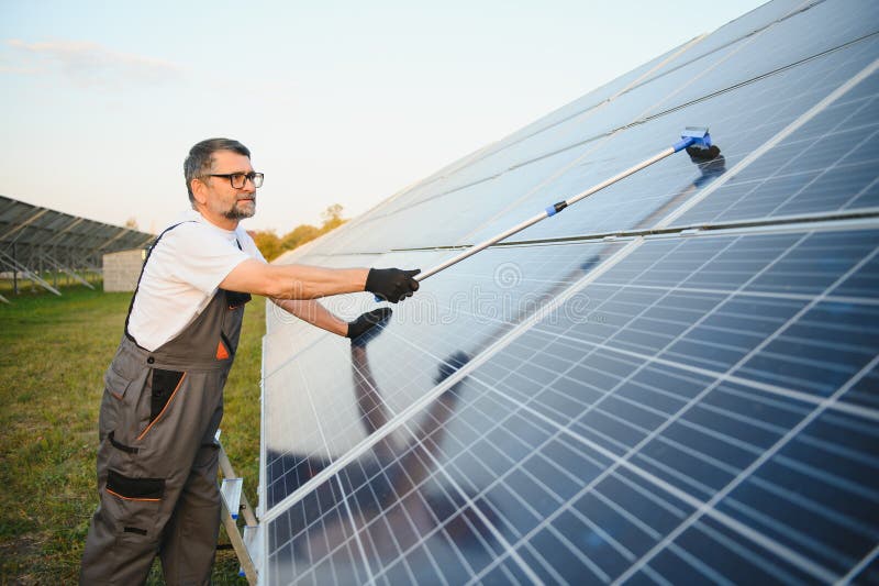 Professional Worker Cleaning Solar PV Panel. Man Making Sure Solar ...
