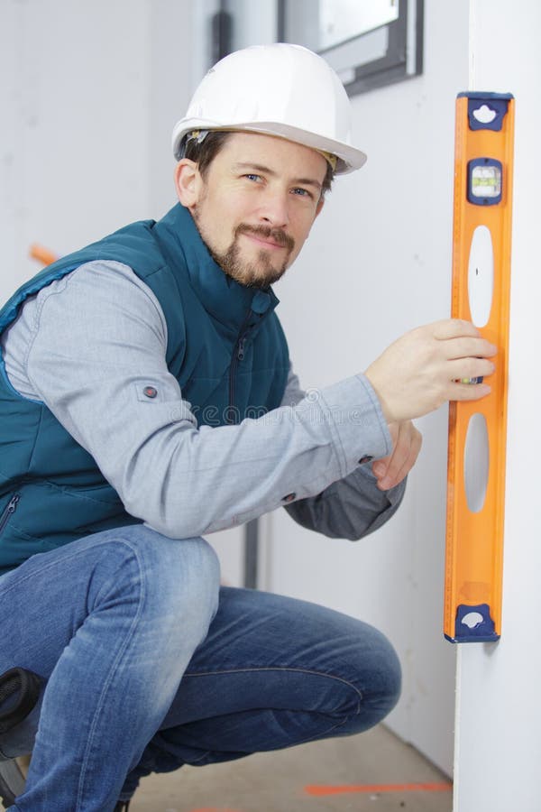 Professional Worker in Helmet Measuring Wall with Level Stock Photo ...