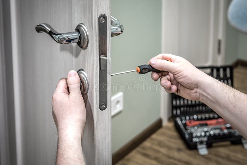 Professional Worker Installing the Part of Lock in Wooden Door by the ...