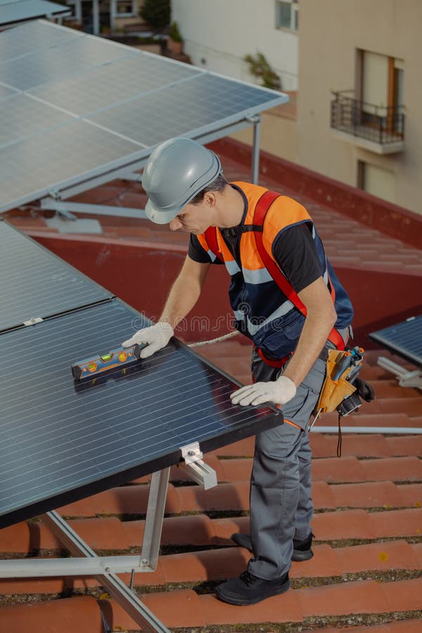 Professional Worker Installing Solar Panels on the Roof of a House ...