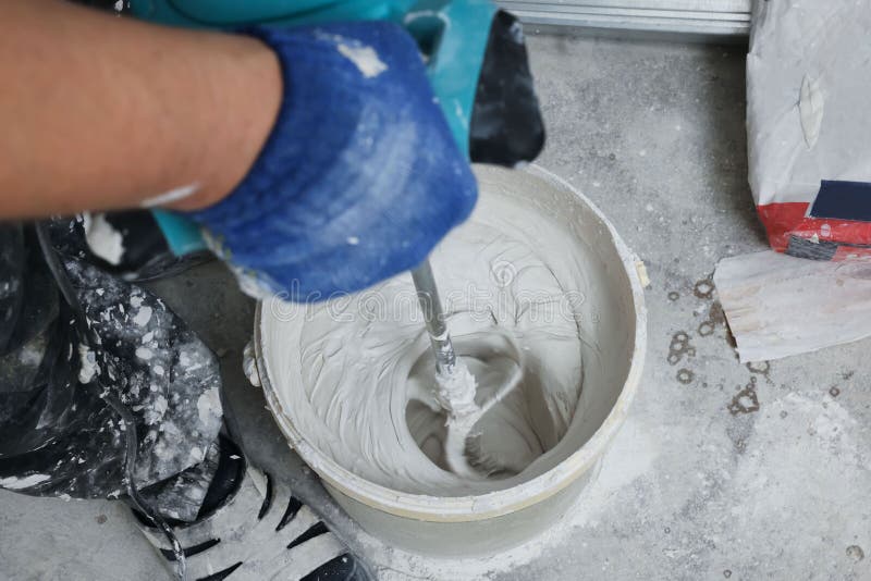 Professional Worker Mixing Plaster in Bucket Indoors, Closeup Stock ...