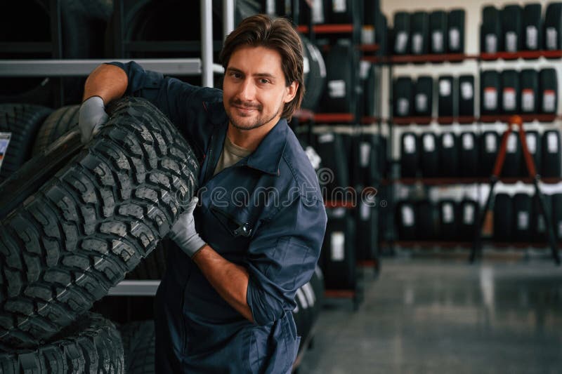 Professional Worker is with Wheel. Man is in the Tire Fitting Car ...