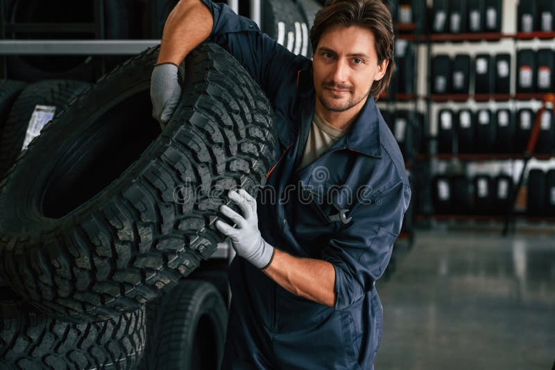Professional Worker is with Wheel. Man is in the Tire Fitting Car ...