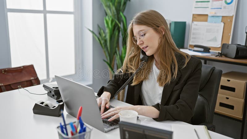 A Professional Young Woman Multitasks in a Modern Office, Engaging with ...