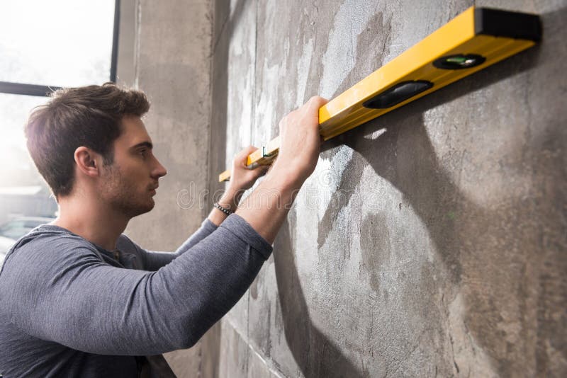 Professional Young Worker Measuring Wall with Level Tool Stock Image ...