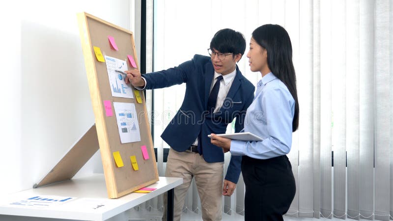 Professionals Businessman and Businesswoman Discussing Over Sticky ... Professionals Businessman and Businesswoman Discussing Over Sticky ...