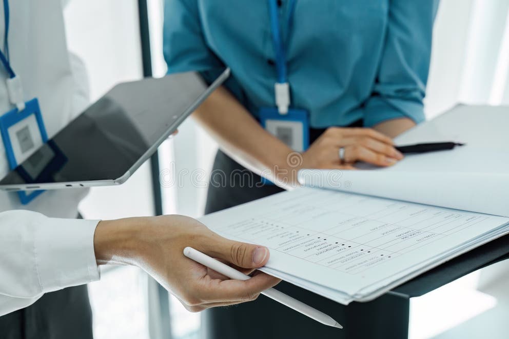 Professionals Reviewing Documents and Tablets in a Modern Office ...