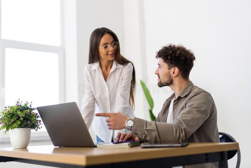 Professionals Standing in an Office and Using a Laptop Together. Two ...