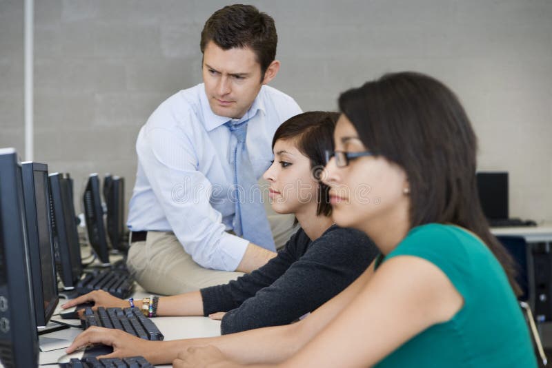 Teacher Assisting College Student in Computer Lab Stock Image - Image ...