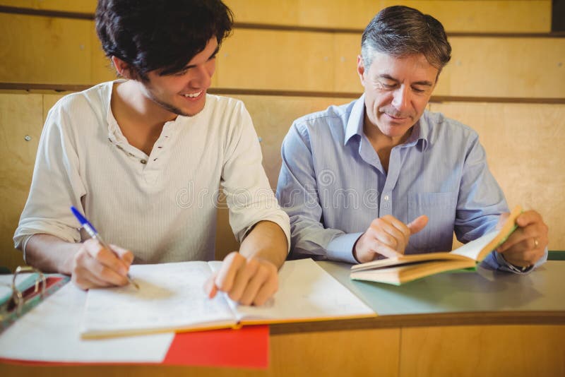 Professor Assisting a Student with His Study Stock Image - Image of ...