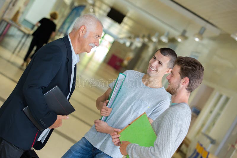 Professor Com Caderno Que Fala Ao Estudante No Corredor Imagem de Stock ...