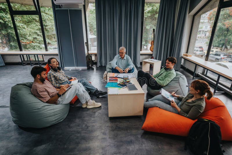 Professor Engaging with Students in a Modern Study Lounge Setting Stock ...