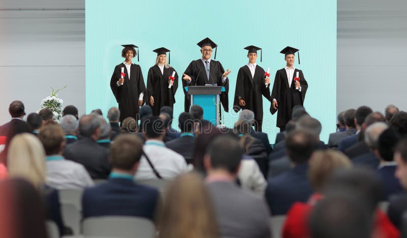 Professor and Graduate Students Standing on a Podium in Front of People ...