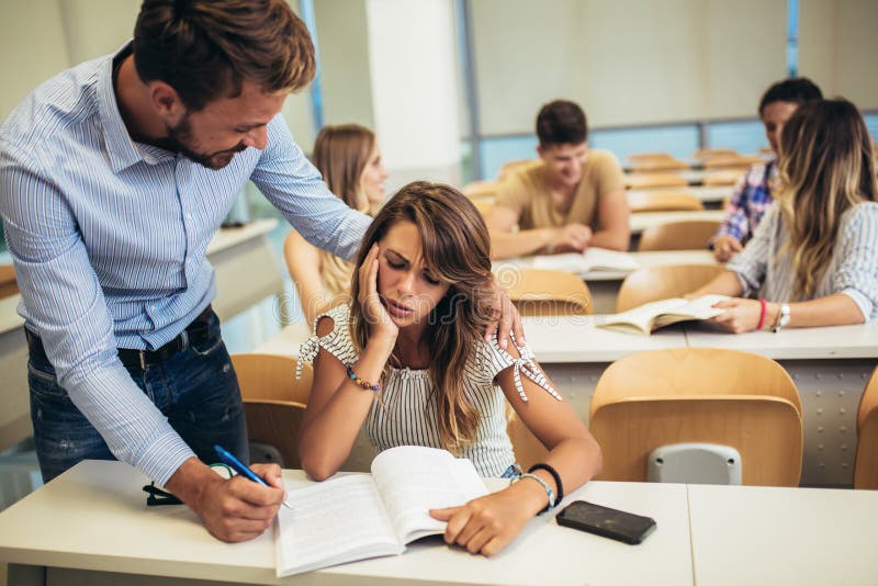 Professor Helping a Student in Classroom Stock Photo - Image of ...