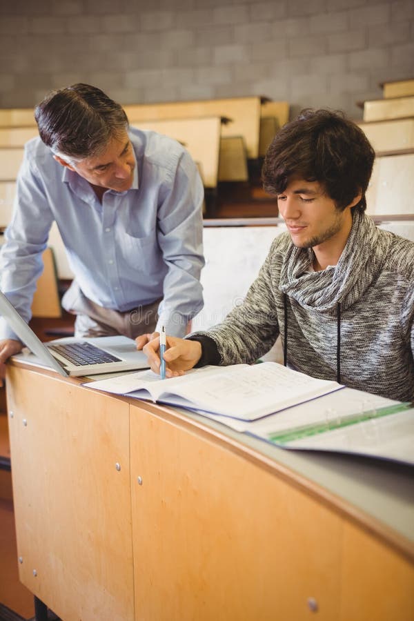 Professor Helping a Student in Classroom Stock Image - Image of ...
