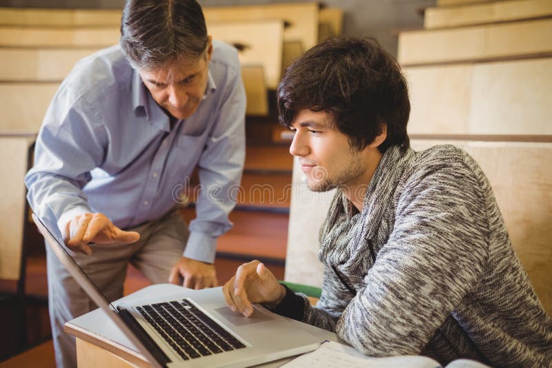 Professor Helping a Student in Classroom Stock Photo - Image of ...