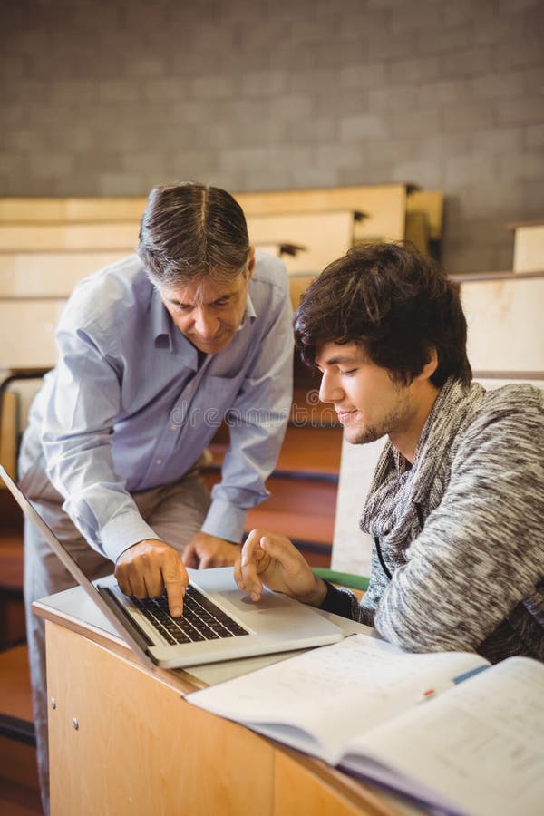 Professor Helping a Student in Classroom Stock Photo - Image of ...