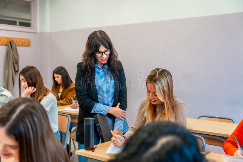 Professor Helping Student during Exam at University Classroom Stock ...