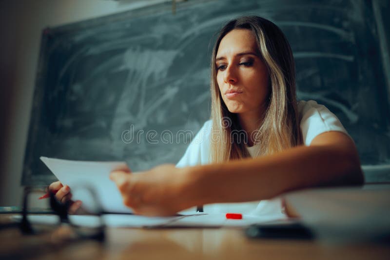 Serious Teacher Reading an Assignment Grading it Stock Image - Image of ...