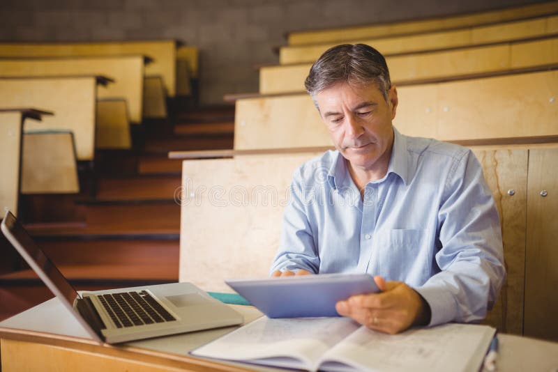 Professor Sitting at Desk Using Digital Tablet Stock Image - Image of ...