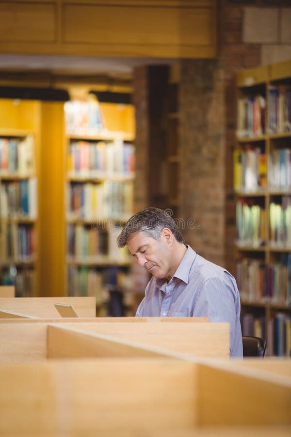 Professor Sitting on Desk Using His Laptop Stock Photo - Image of notes ...