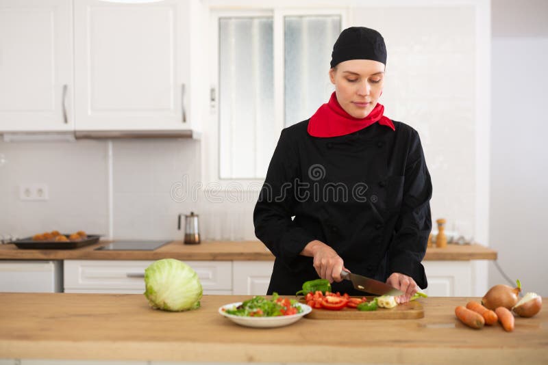 Female Cook in Black Uniform Chopping Vegetables in Kitchen Stock Photo ...