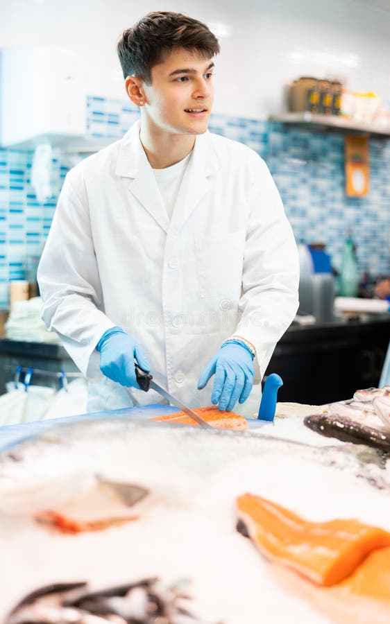Proficient Salesman Cutting Fish Fillet in Fish Store Stock Image ...