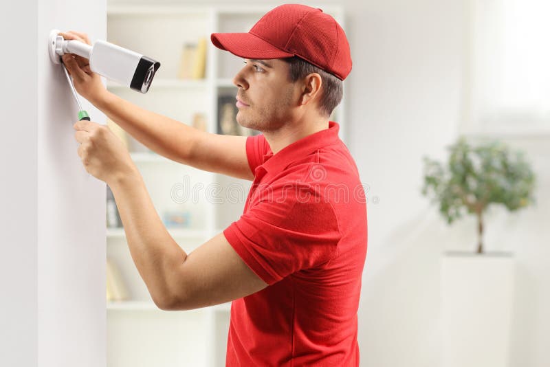 Young Man Installing a Security Camera on a Wall in a Room Stock Image ...