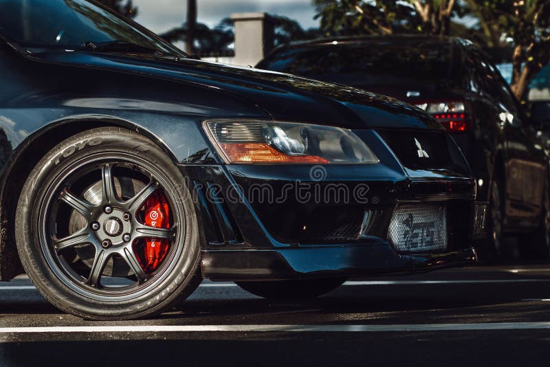 Profile View of the Front Rim of a Dark Blue Mitsubishi Evo 7 Car in a ...