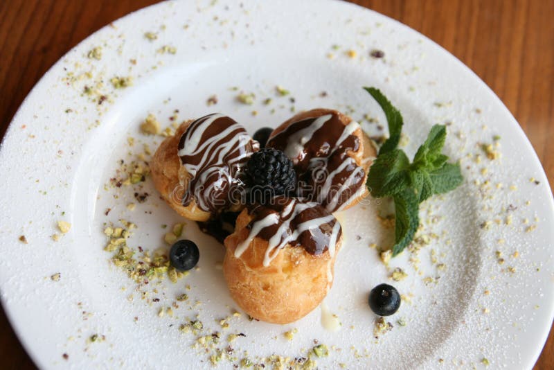 Profiteroles with Berries on White Plate Stock Image - Image of white ...