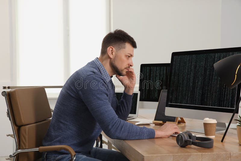 Programmer Talking on Phone while Working at Desk in Office Stock Image ...