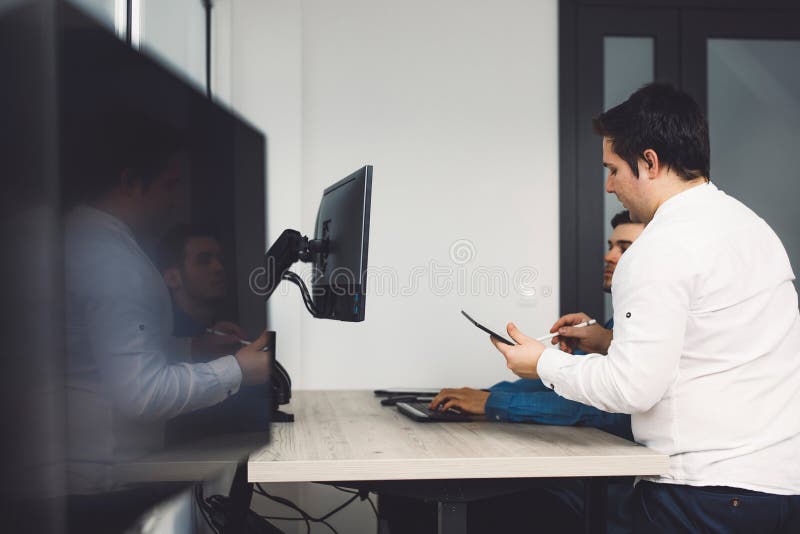 Side View of Two Colleagues Working on a Project Together Developing a ...
