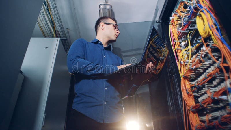 Programmer is Working with His Laptop while Standing Near Plugged ...