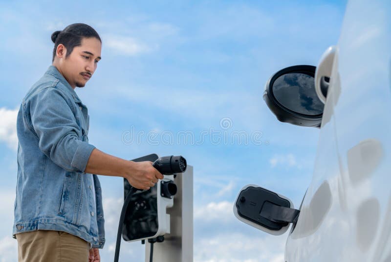 Progressive Man with Plugged-in EV Car with Charging Point, Cloudscape ...