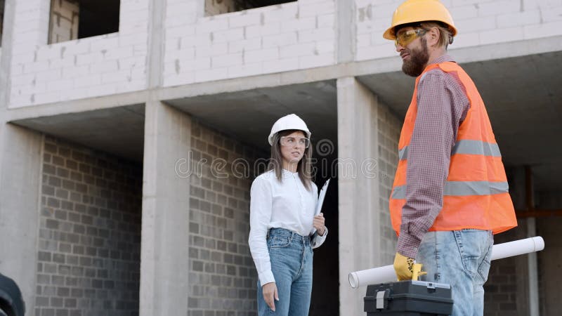 Construction Site Meeting with a Project Manager Discussing Plans Amid ...