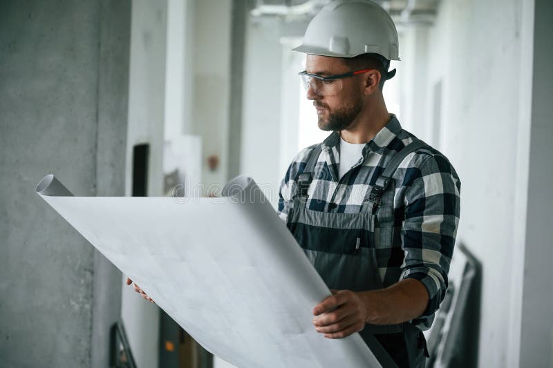 Project on the Paper, Holding in Hands. Construction Worker in Uniform ...