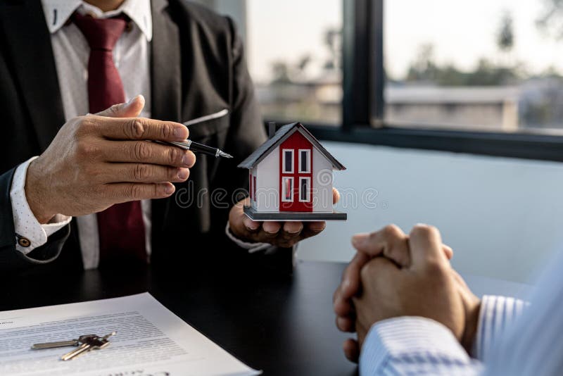 The Property Salesman on the Project is Pointing To a Model of a Small ...