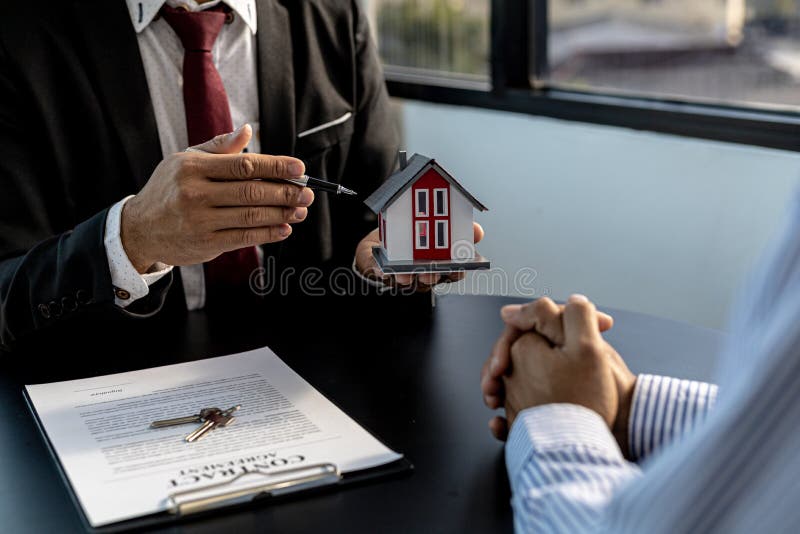 The Property Salesman on the Project is Pointing To a Model of a Small ...