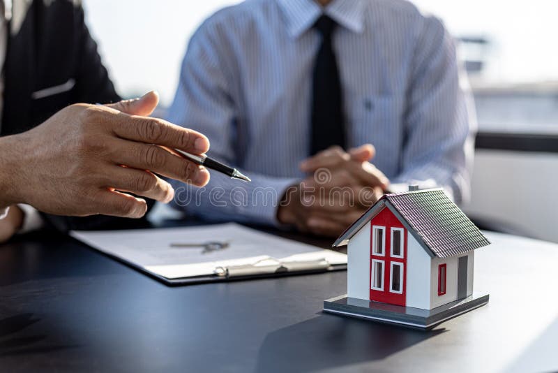 The Property Salesman on the Project is Pointing To a Model of a Small ...