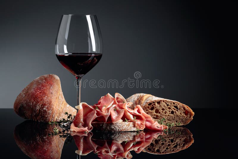 Prosciutto with Ciabatta, Red Wine and Thyme on a Black Background ...